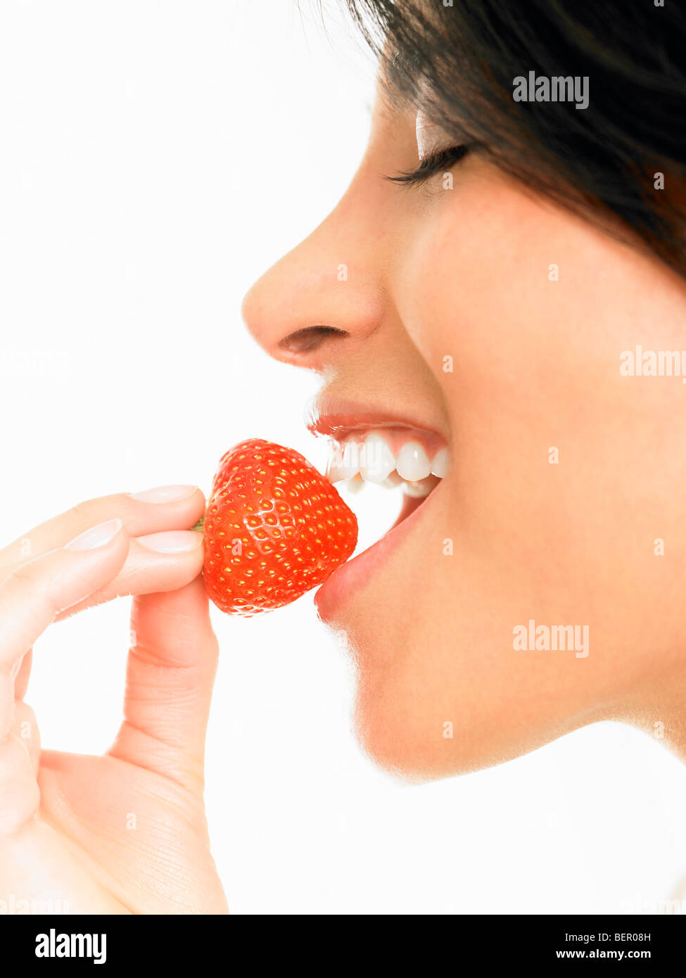 Woman eating a strawberry Stock Photo - Alamy