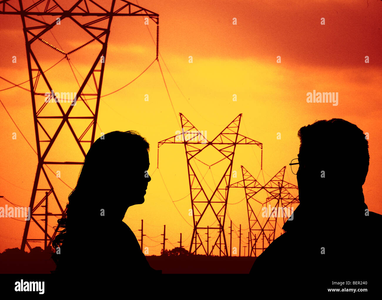 engineering couple checking power line towers at sunset Stock Photo - Alamy