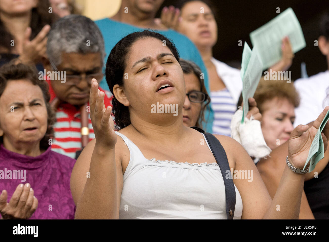 a woman pray during a religious ceremony at a Catholic church in Brazil ...