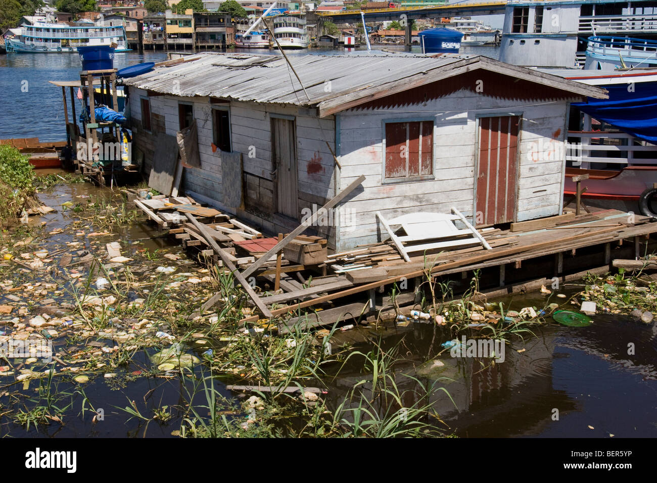 a run down shanty floating house rests on the blacks waters of the Rio ...