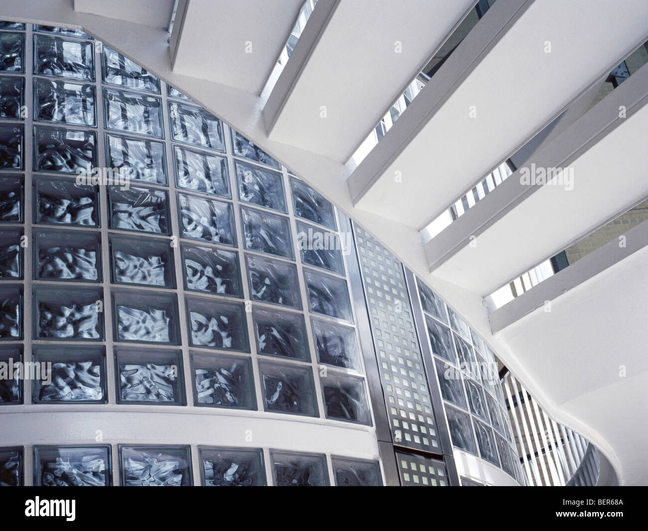 Modernist steel stairway around a glass brick lift shaft Stock Photo ...