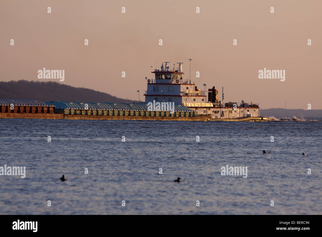 Pushing a few barges north along the Mississippi River, a large tug ...