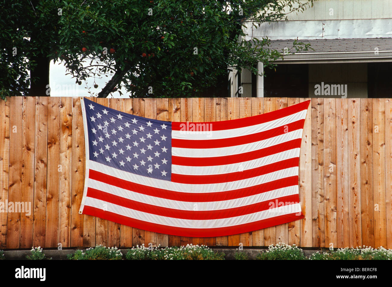 American flag hangs on wood fence in residential neighborhood, Portland ...