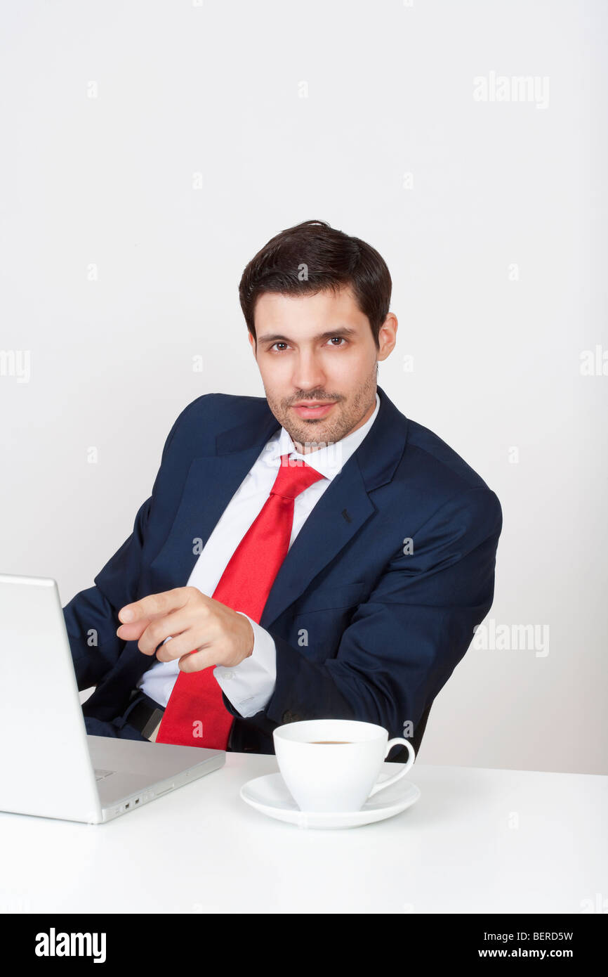 young business executive in suit behind desk with laptop Stock Photo ...