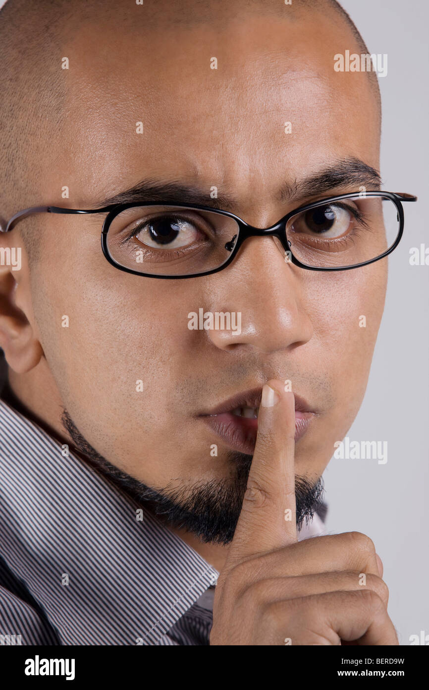 Man gesturing to be quiet Stock Photo - Alamy