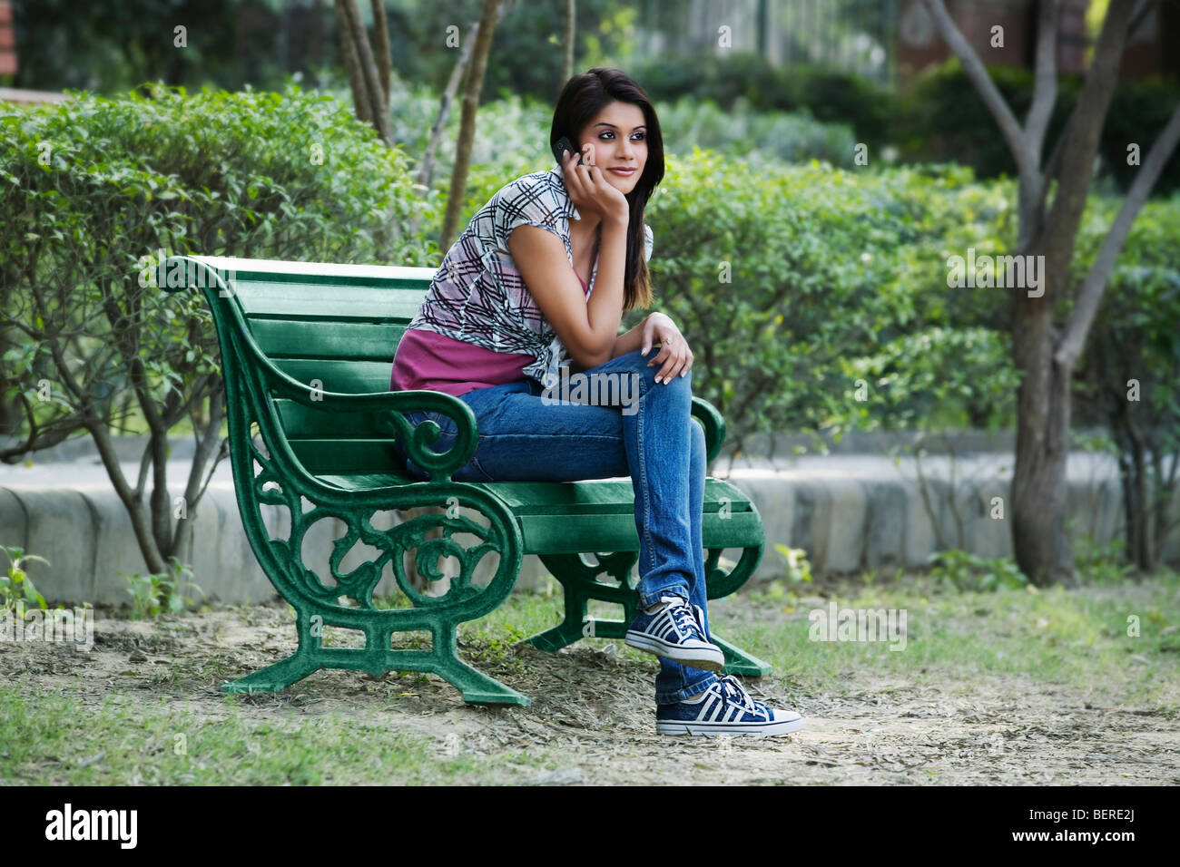 Young woman sitting on a bench Stock Photo - Alamy