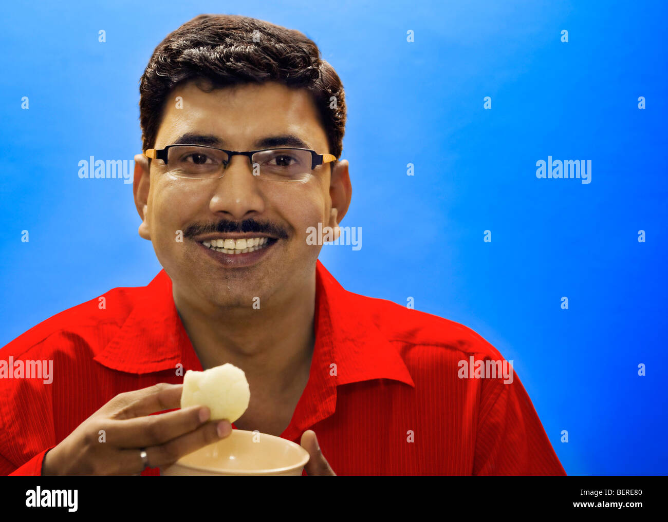 Indian man eating sweet hi-res stock photography and images - Alamy