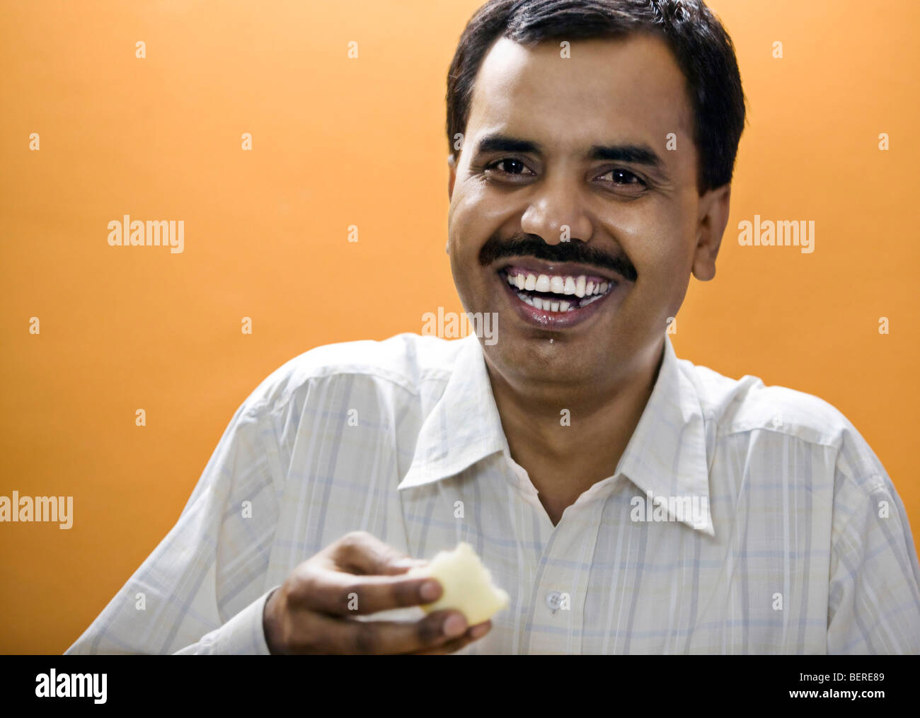 Indian man eating sweet hi-res stock photography and images - Alamy
