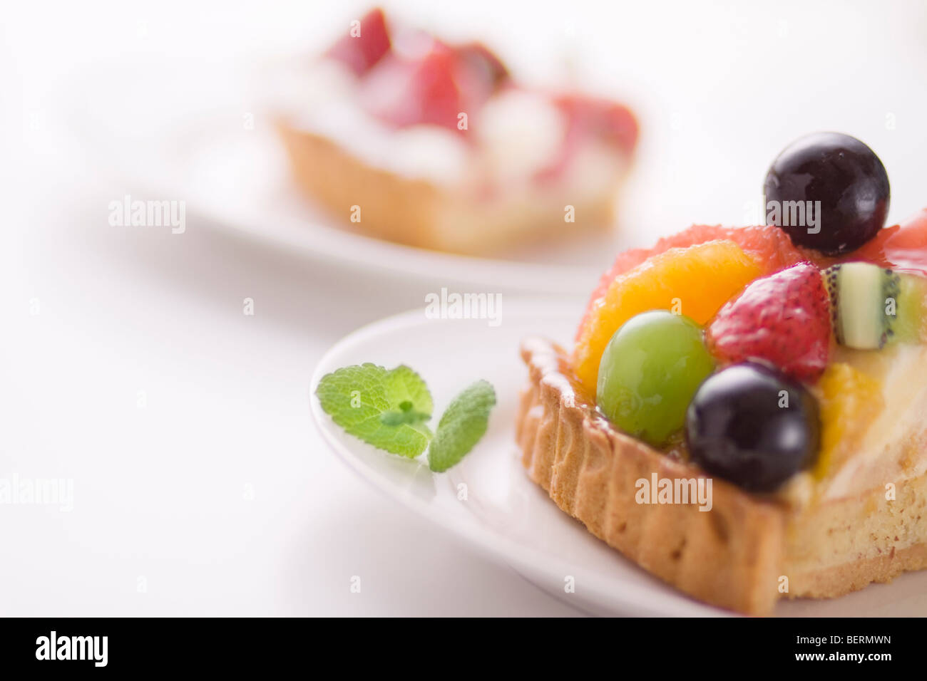 Pieces of tart on plates, close up, white background Stock Photo - Alamy