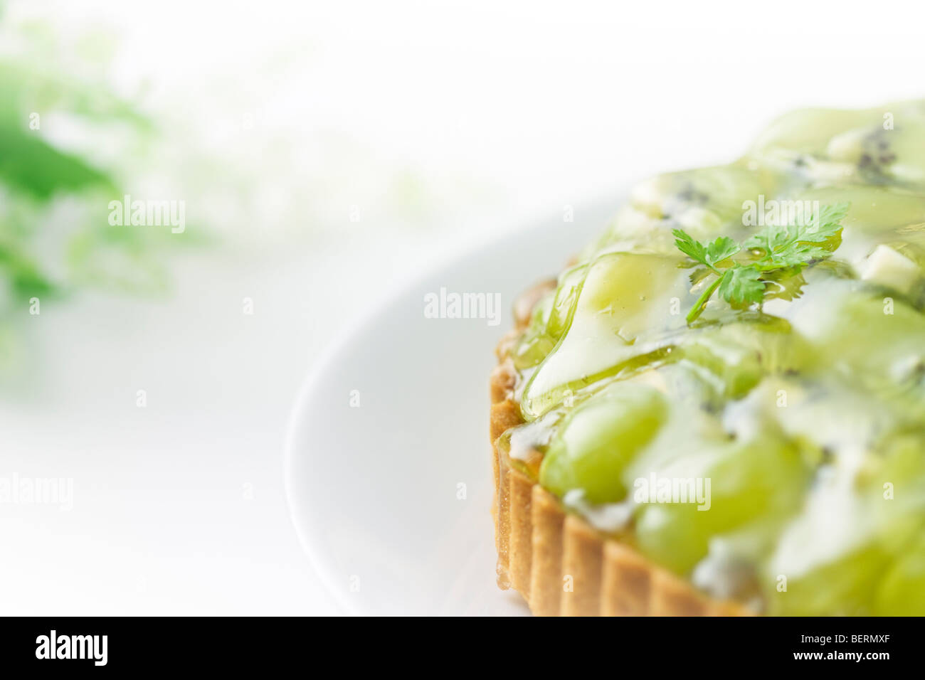 Muscat grape and kiwi tart on plate, close up, white background Stock ...