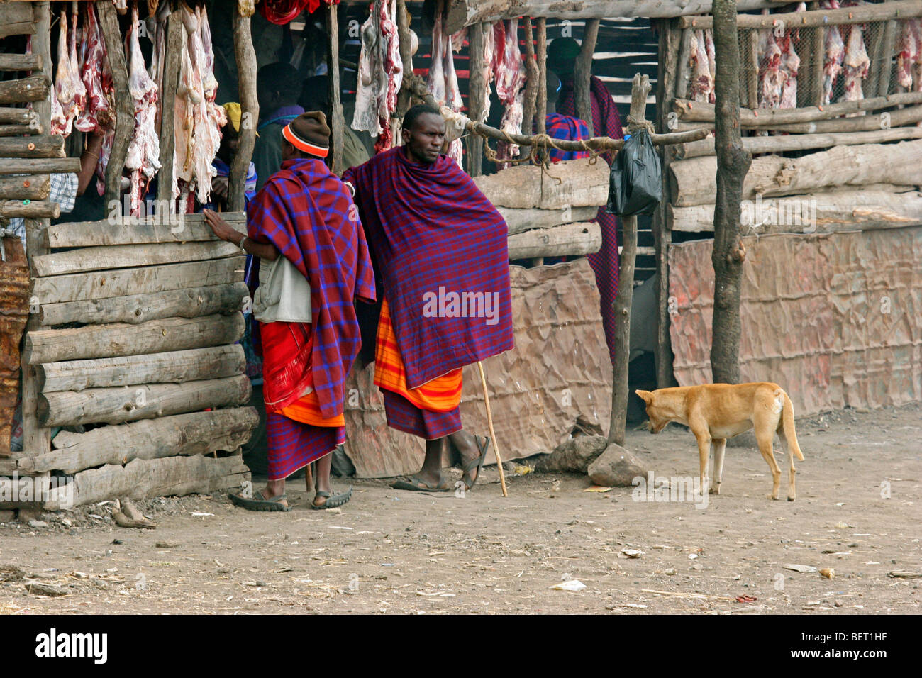 Maasai men buying meat at primitive butcher's shop in village, Tanzania ...