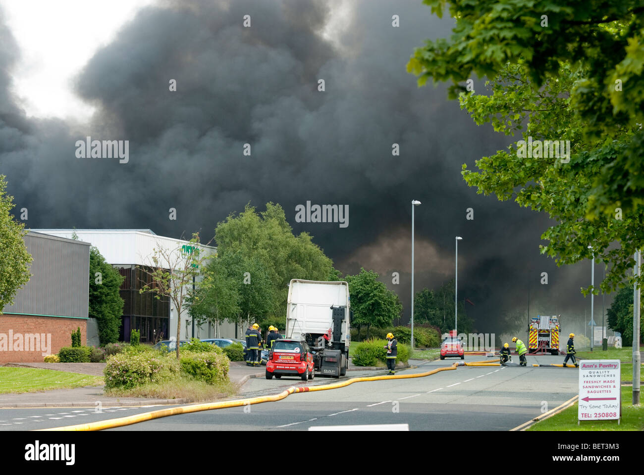 Firemen at scene of large chemical factory fire with smoke Stock Photo ...
