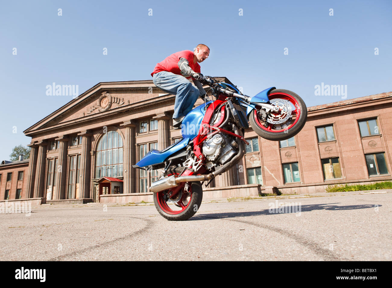 Stunt bike rider making wheelie Stock Photo - Alamy