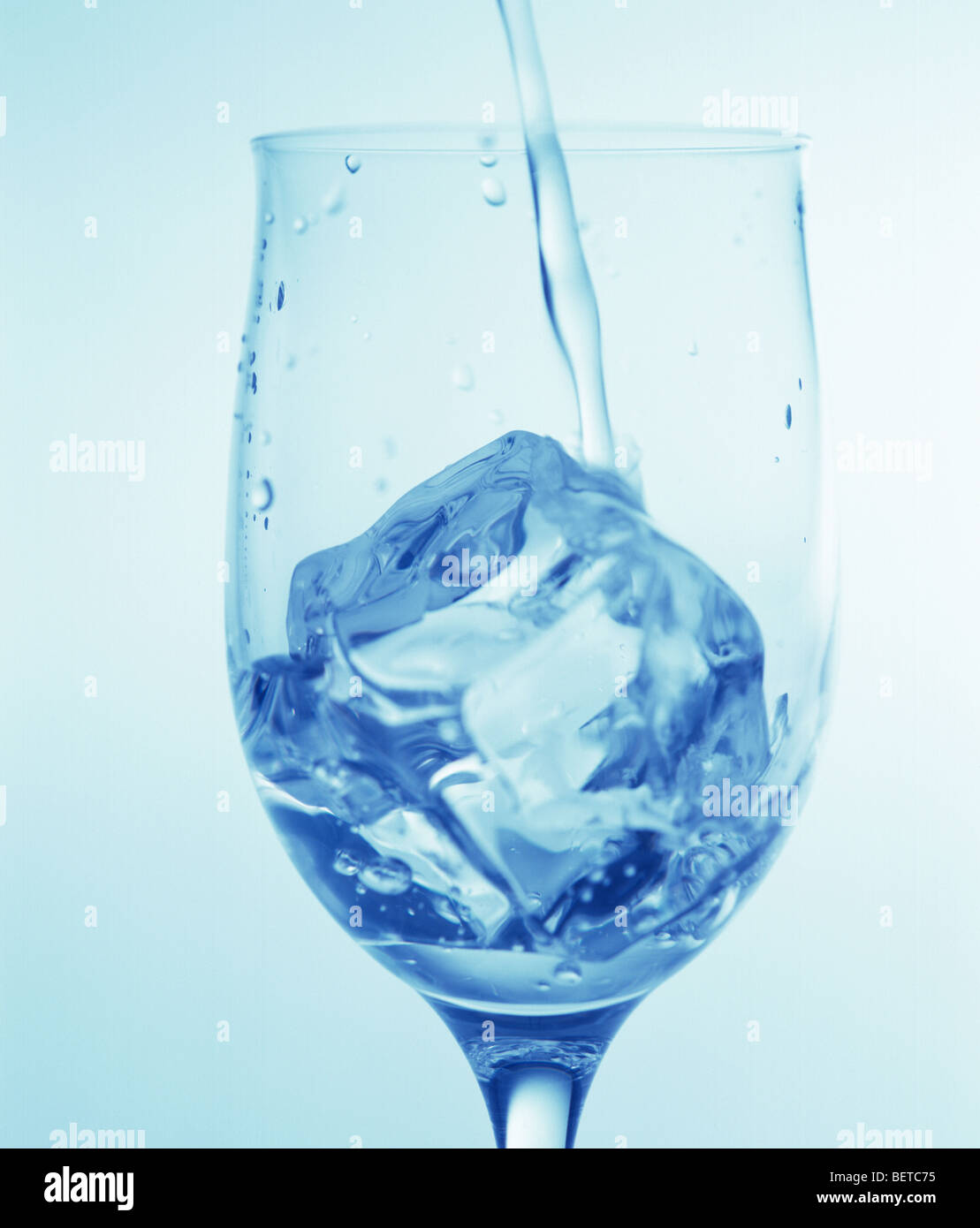 Cocktail being poured over ice into a wineglass Stock Photo - Alamy