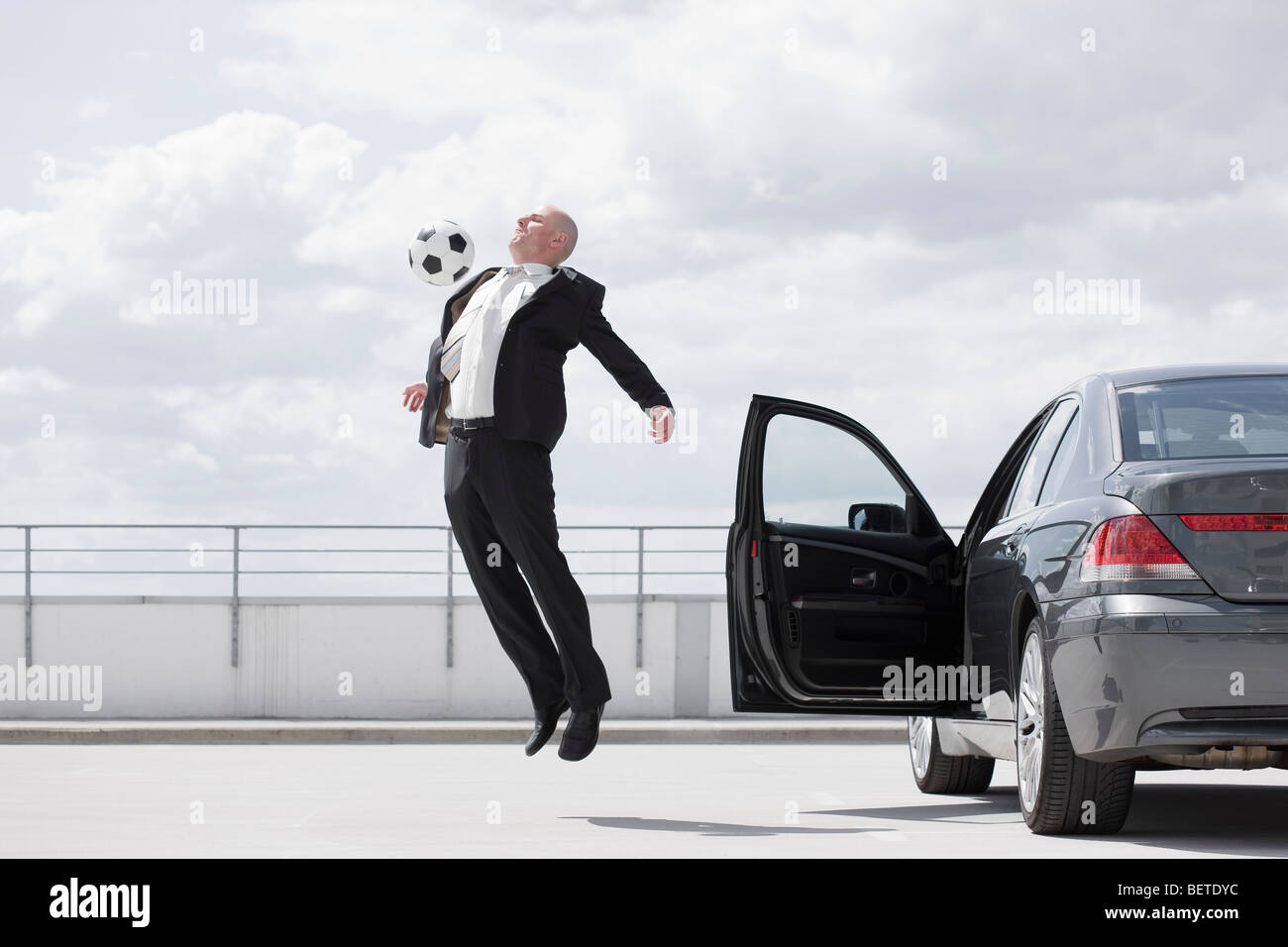 man playing football near car Stock Photo - Alamy