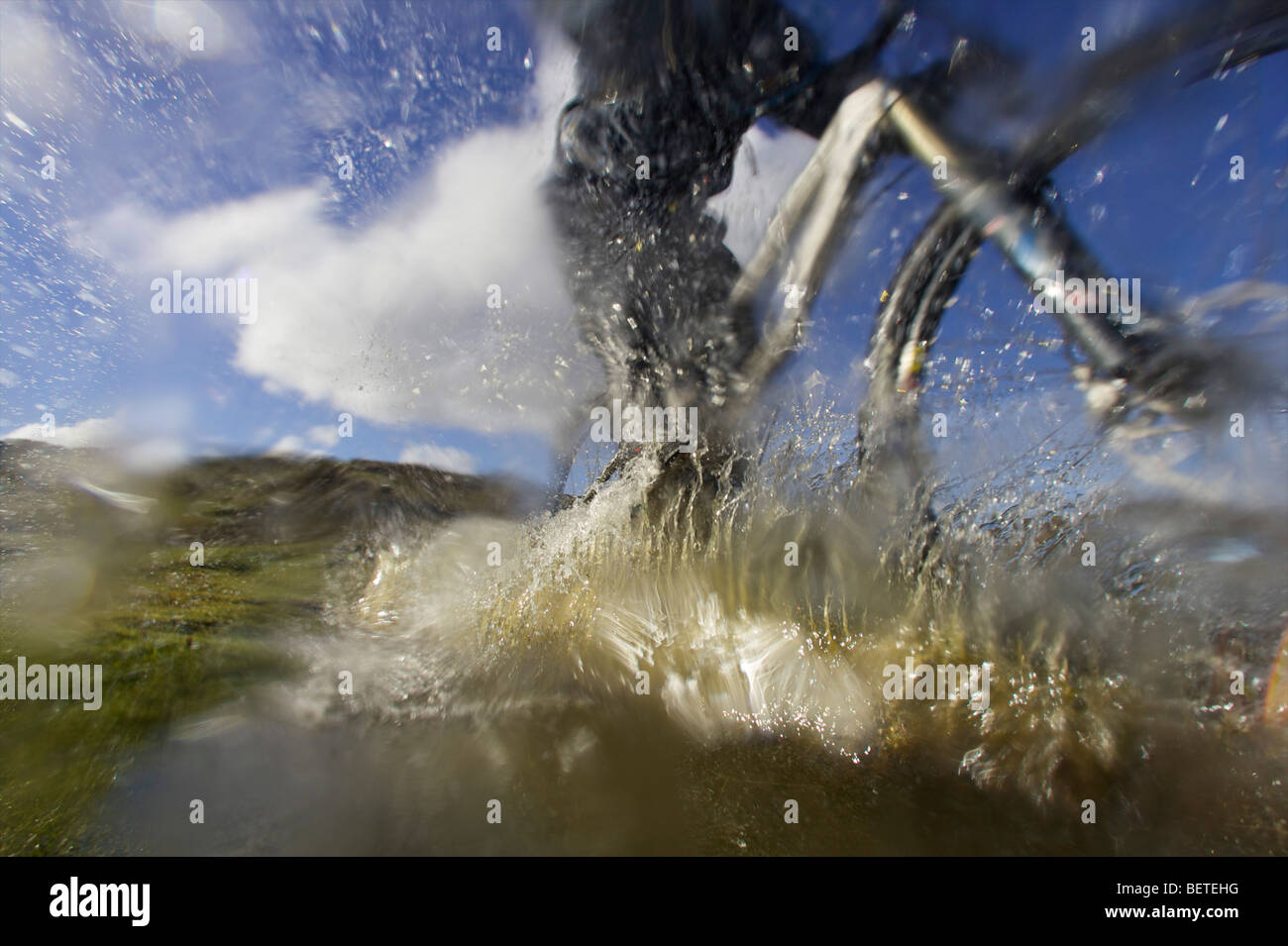Mountain biker riding through a puddle Stock Photo - Alamy