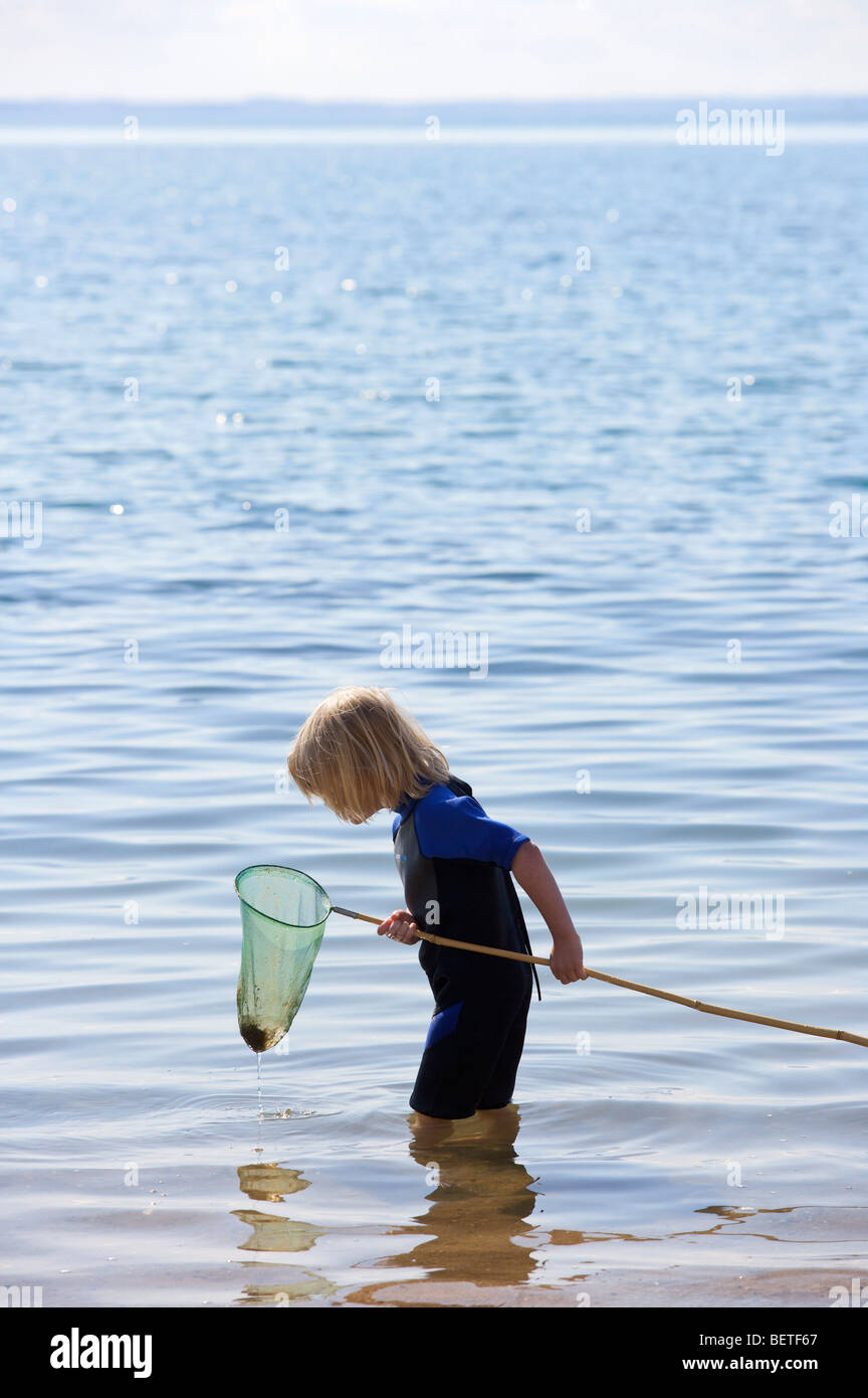 Boy look into a fishing net Stock Photo - Alamy