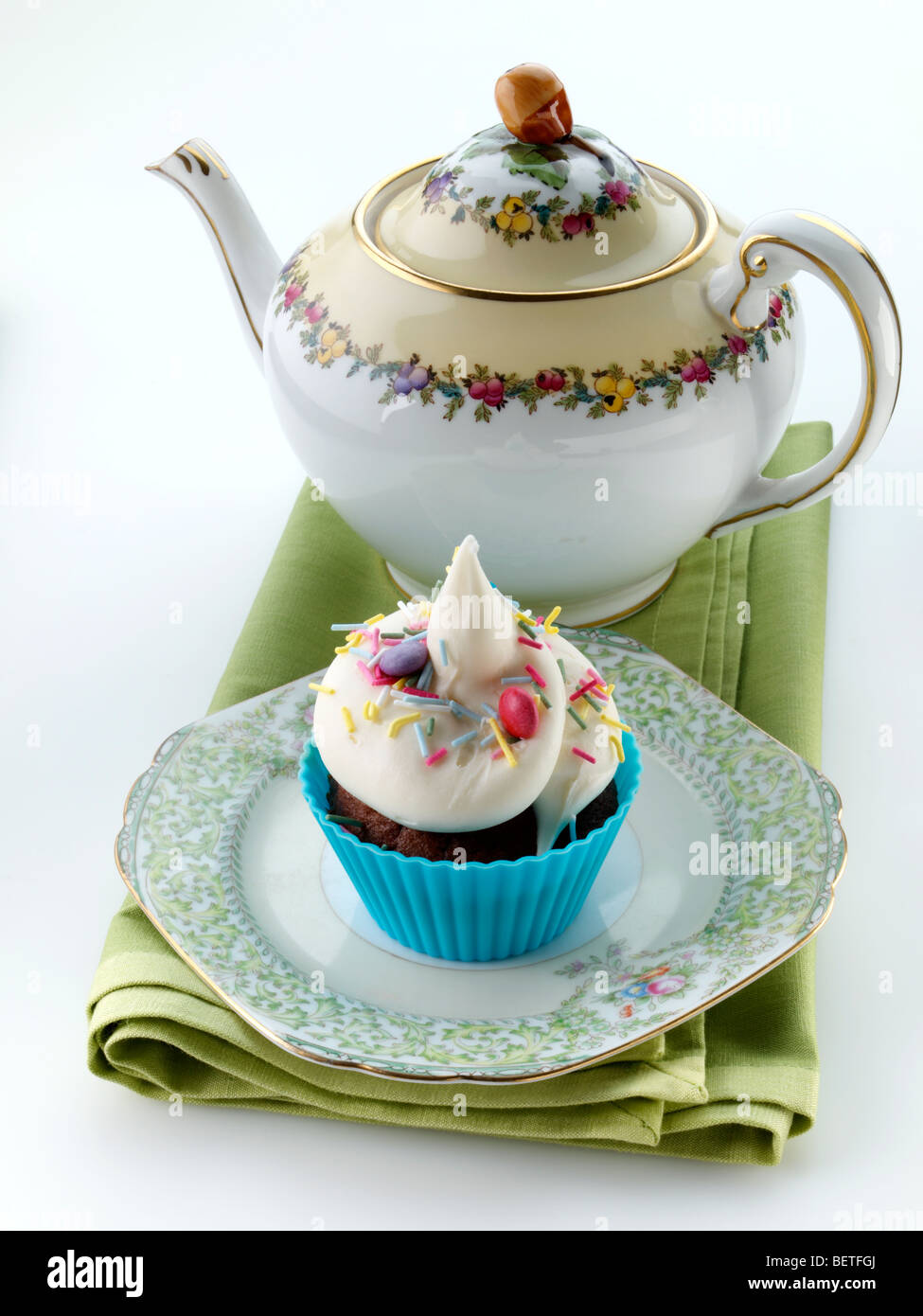Cupcake in a colorful case with an antique teapot Stock Photo - Alamy