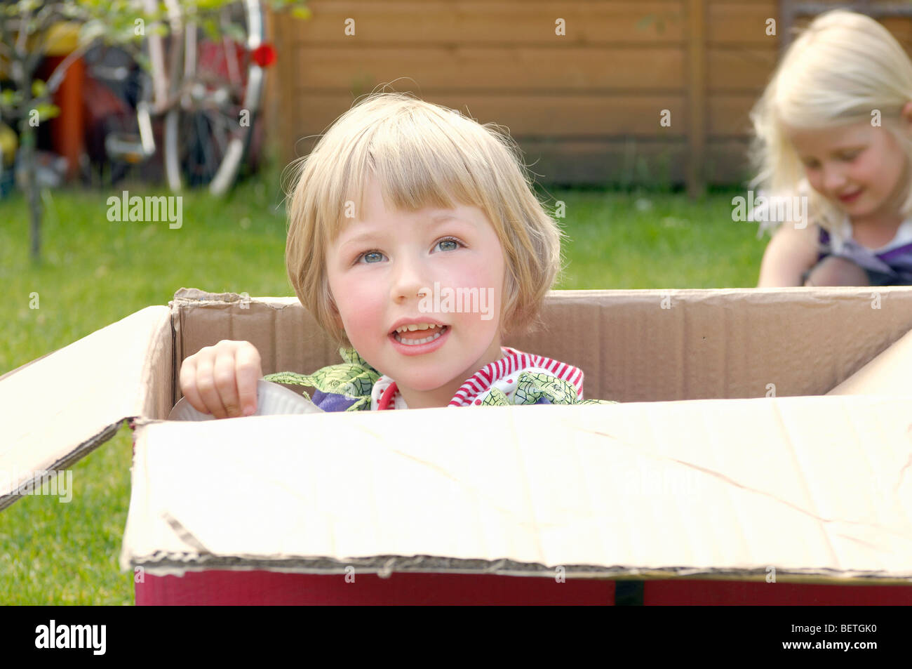 two young girls playing in cardboard box Stock Photo - Alamy