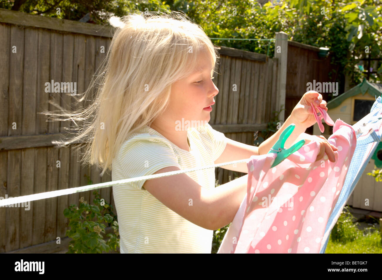 young girl hanging out clothes Stock Photo - Alamy