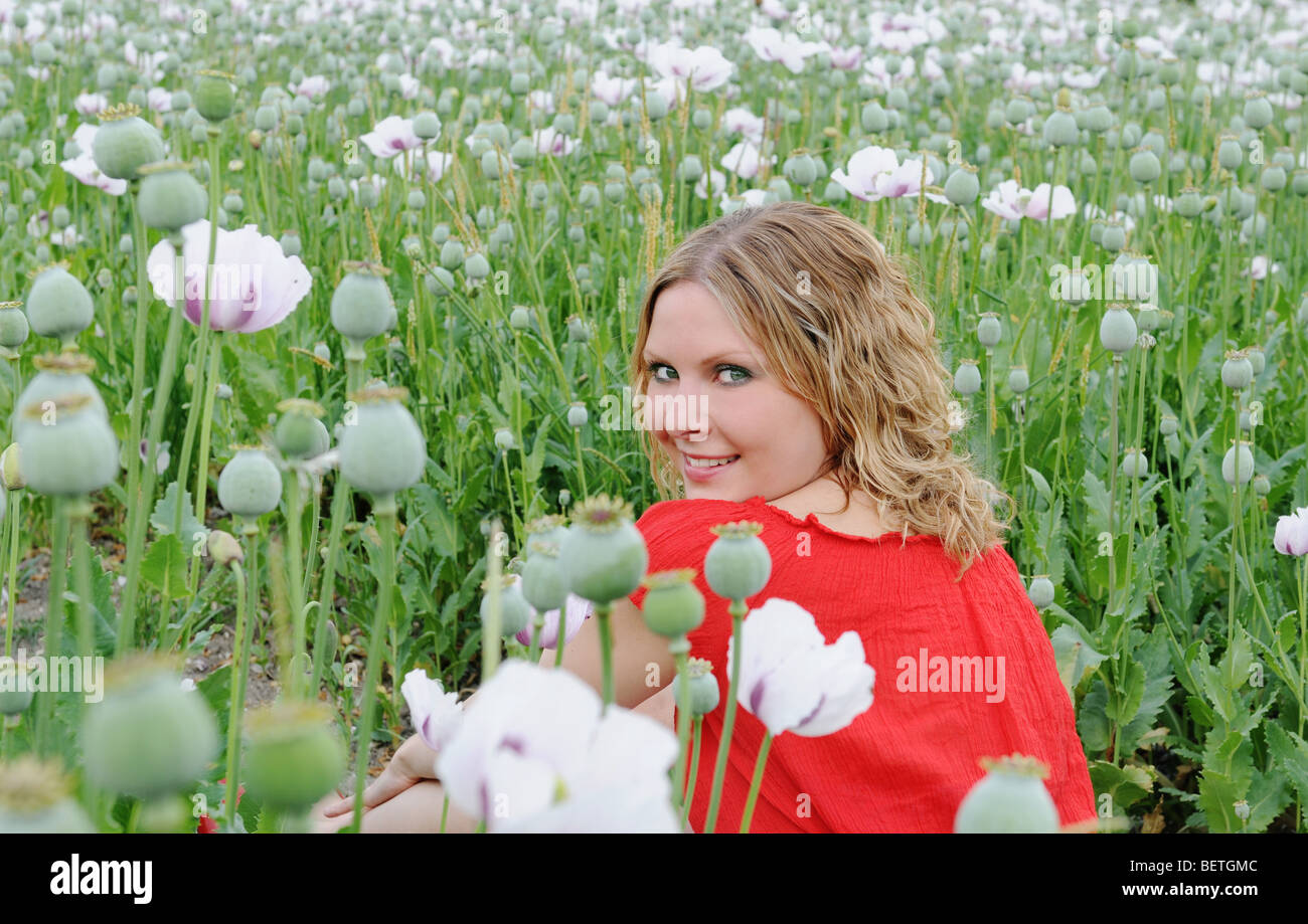 Beautiful Caucasian woman walking in a white poppy field Stock Photo ...