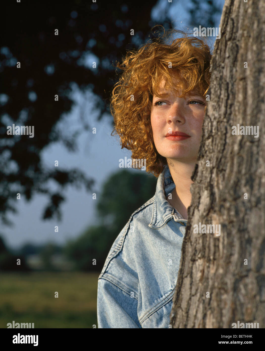 Beautiful blonde behind tree hi-res stock photography and images - Alamy