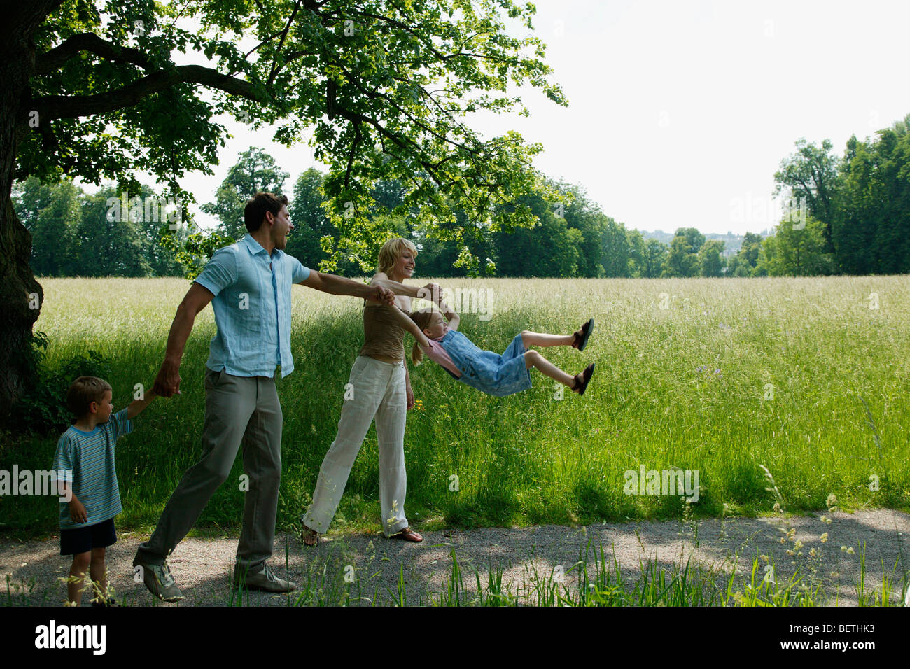 Kids swinging with parents hi-res stock photography and images - Alamy