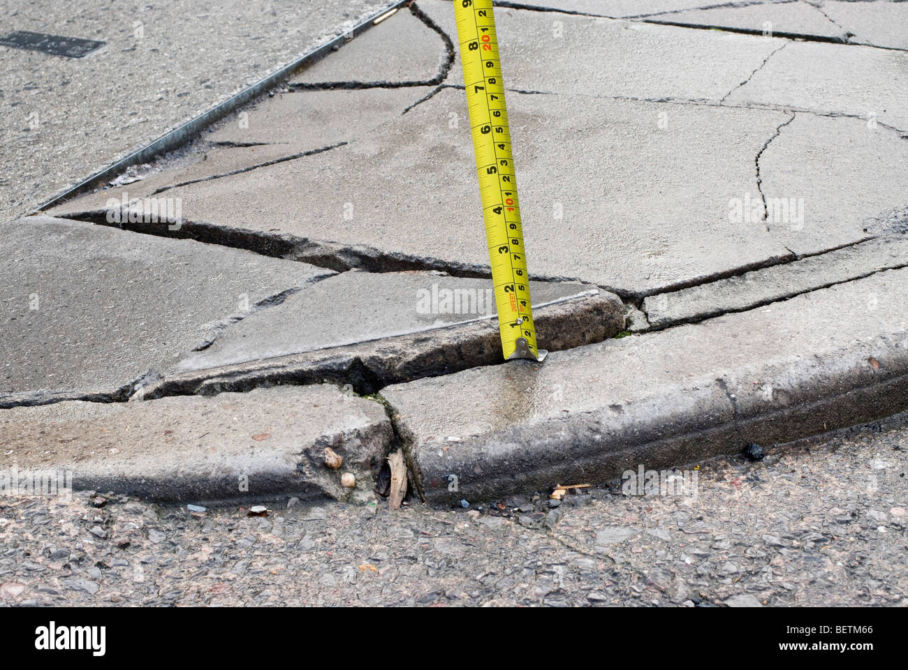 Measuring the height of broken paving stones Stock Photo - Alamy