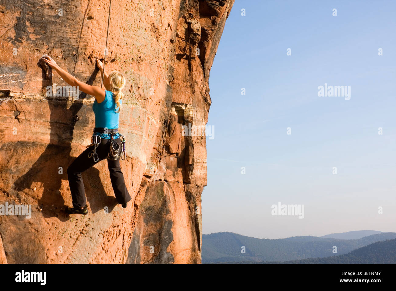 Young woman climbing a rock of sandstone Stock Photo - Alamy
