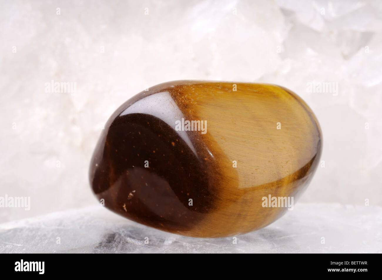 Tiger eye gemstone on quartz background Stock Photo - Alamy