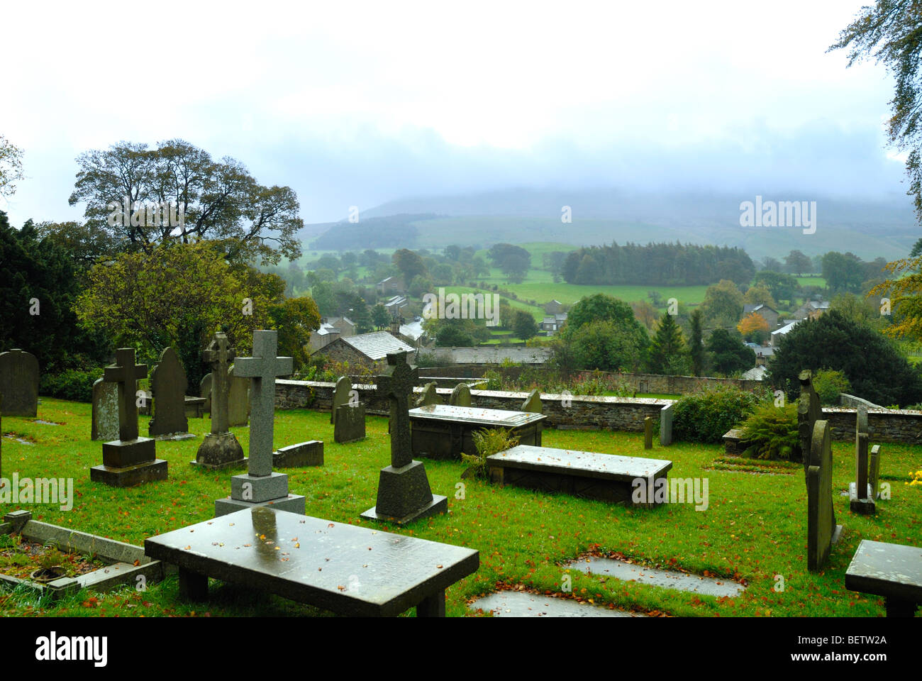 The Churchyard with Pendle Hill shrouded in mist in Downham in the ...