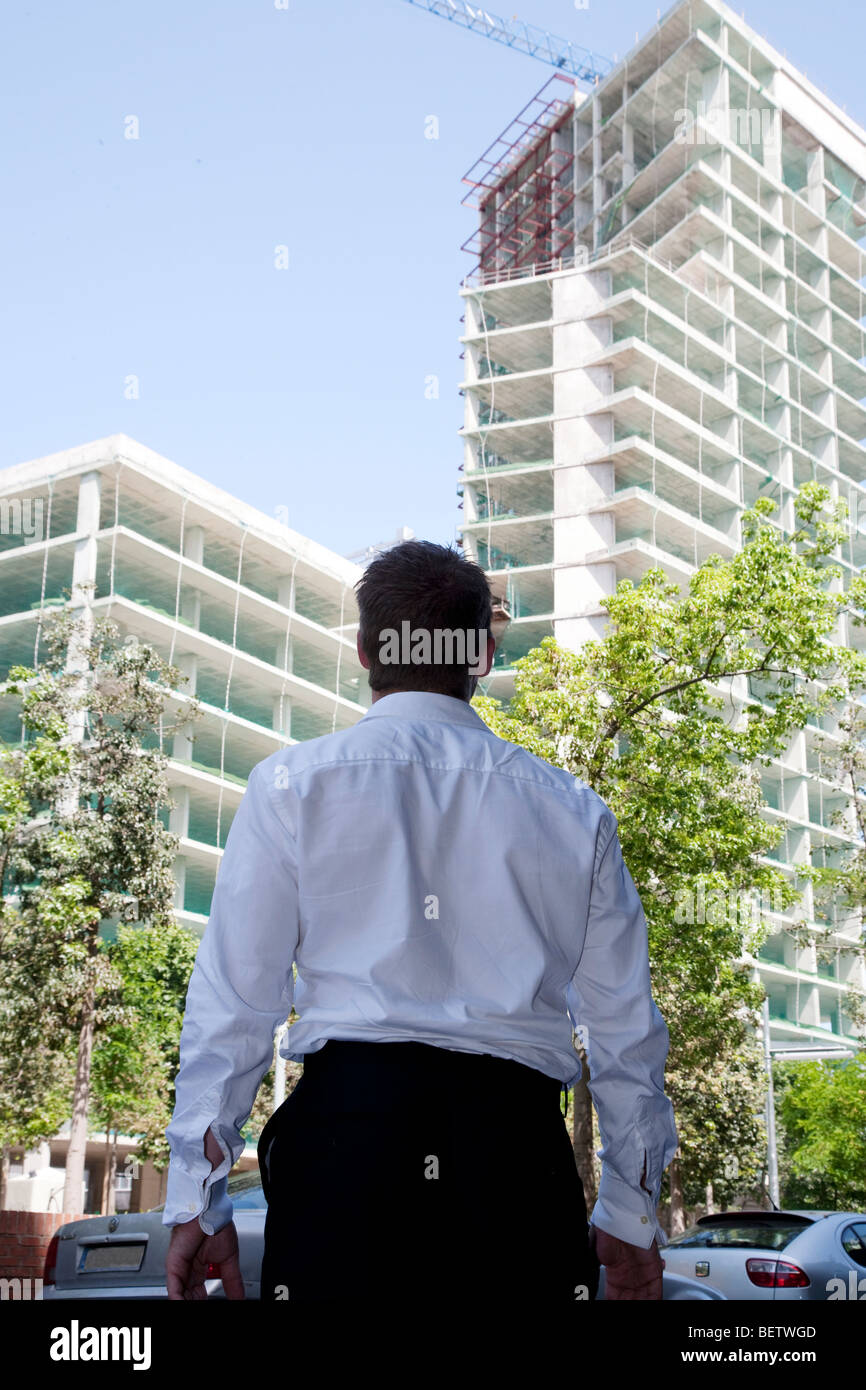 Businessman looking up at a building being built Stock Photo - Alamy