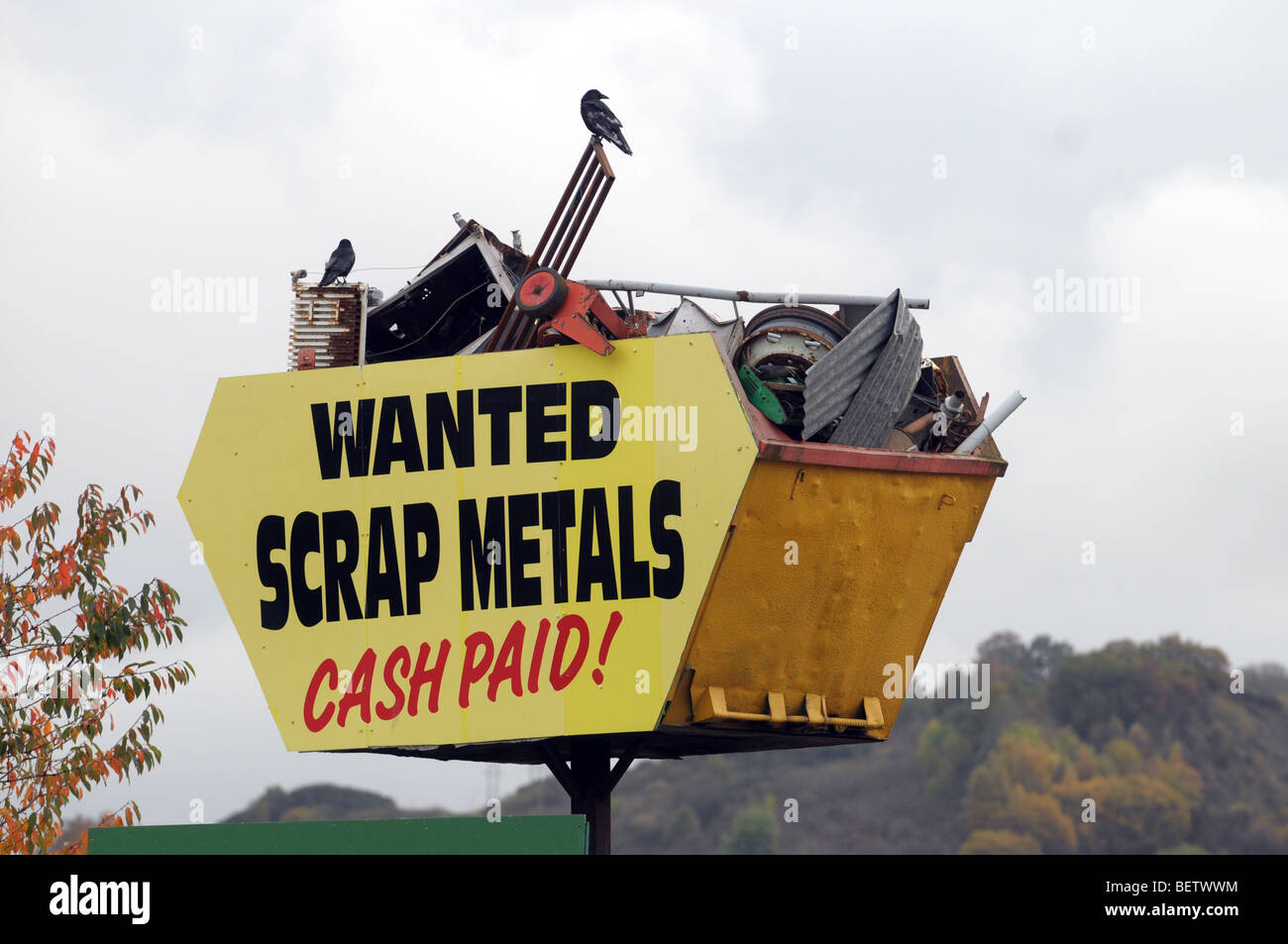 A skip full of scrap metal held aloft to advertise a scrap metal yard ...