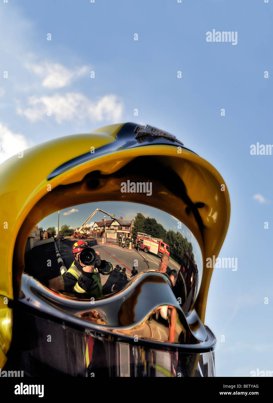 Fireman in Gallet Firefighters yellow helmet with gold visor reflection ...