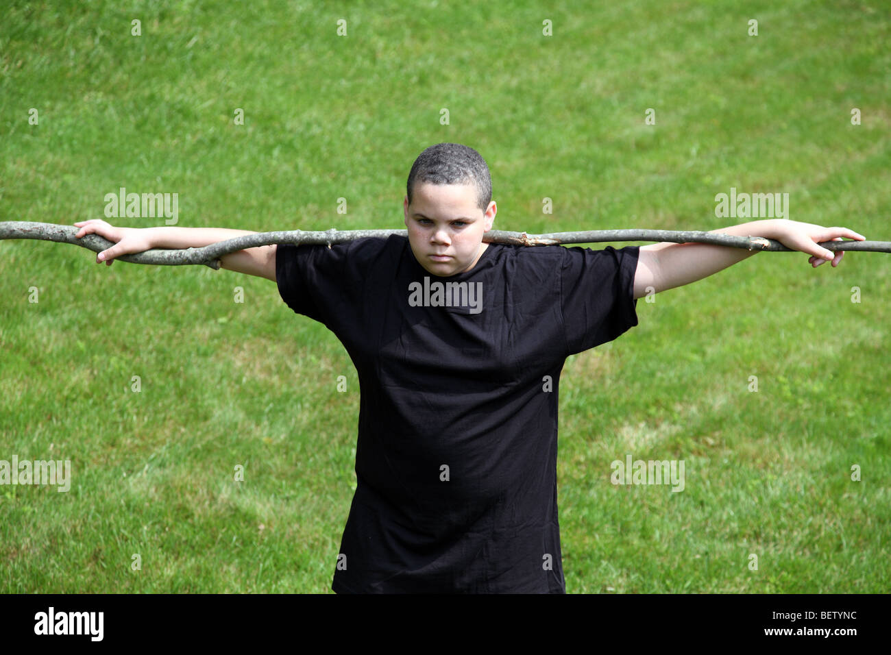 Latino boy holding stick across shoulders Stock Photo - Alamy