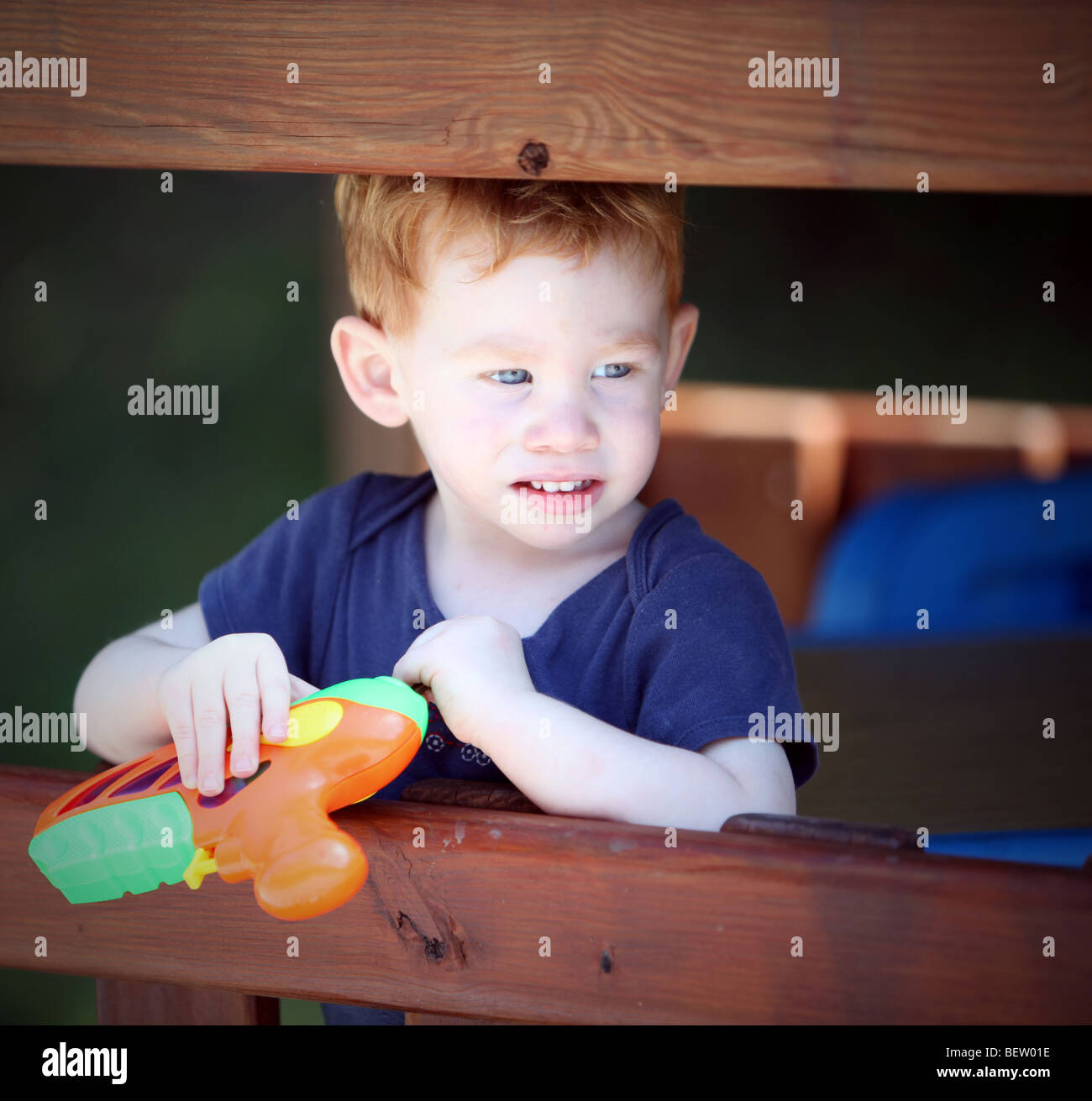 Boy in wooden play fort with toy gun Stock Photo - Alamy