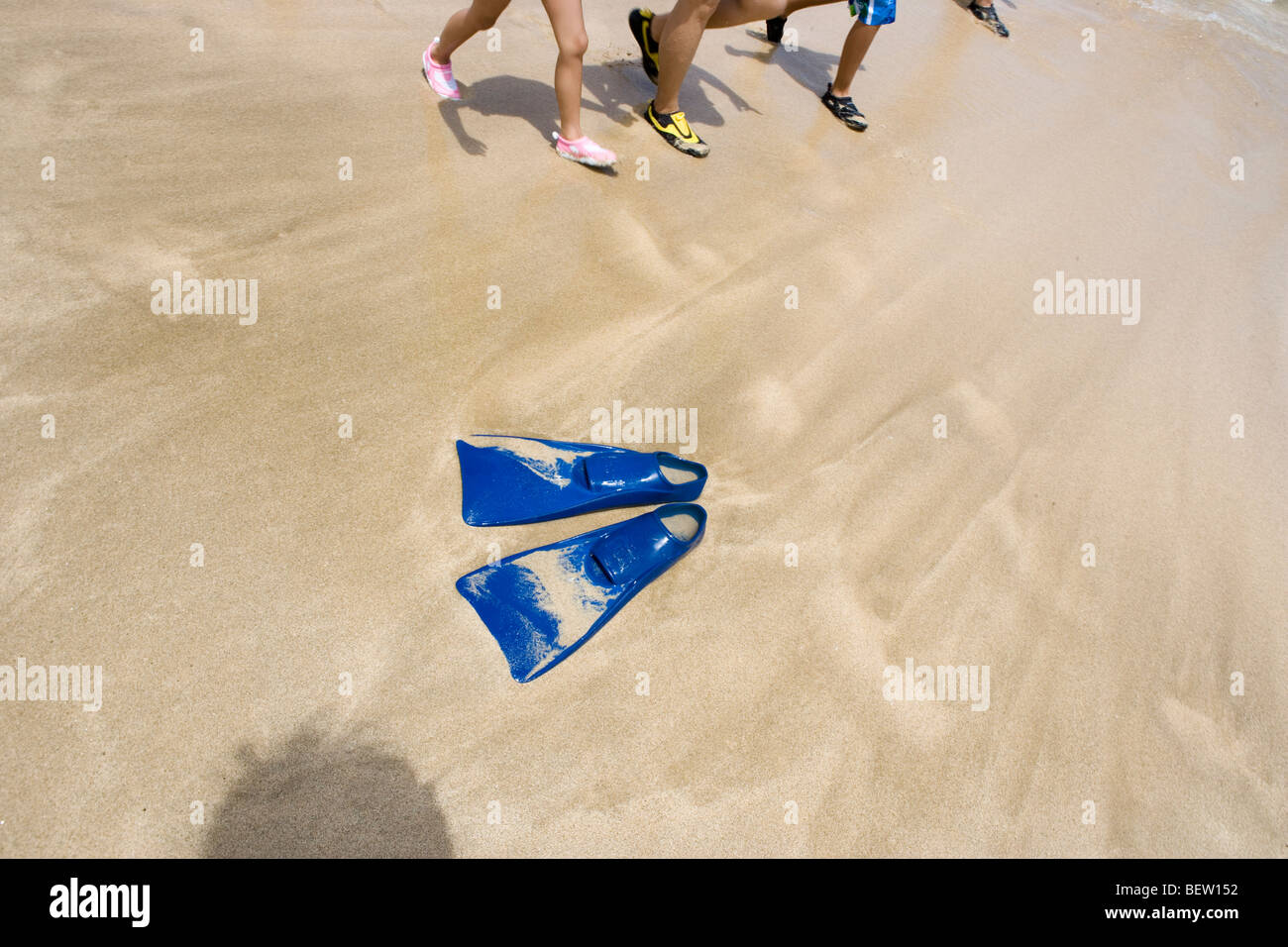 scuba gear flippers left on the beach, kids walking along Stock Photo ...