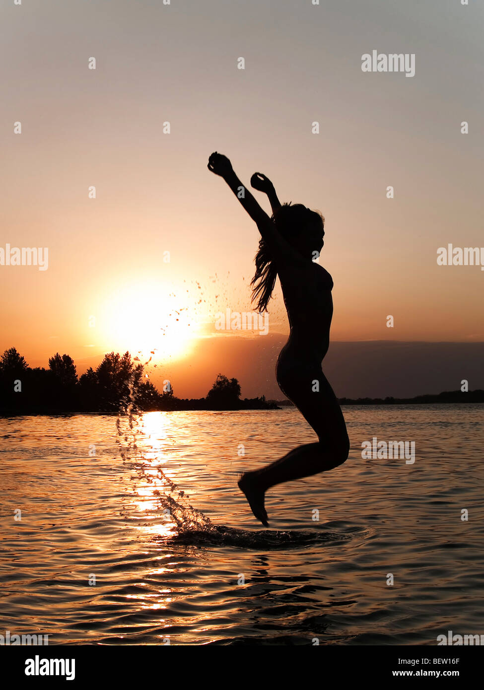 Lady in bikini jumping above water on sunset Stock Photo - Alamy