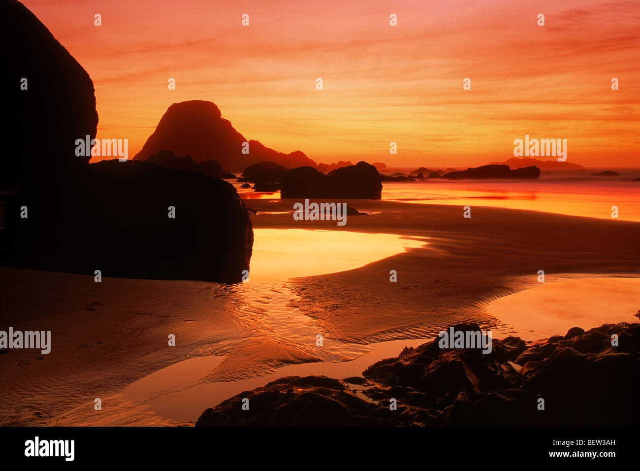 Bandon Beach along Coquille River between painted sunset skies and tide ...