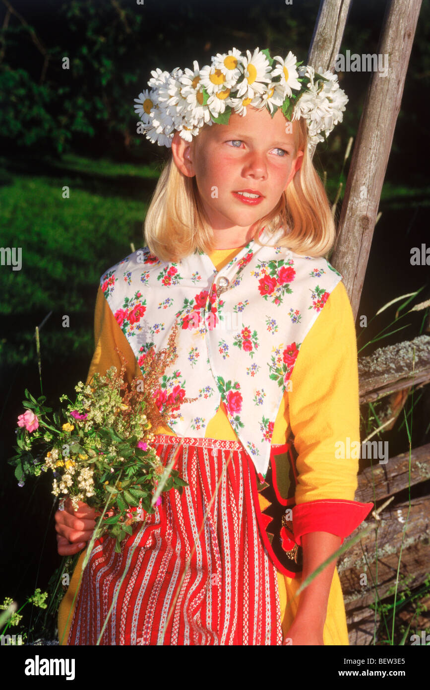Girl in colorful Midsummer dress picking wildflowers in Sweden Stock ...