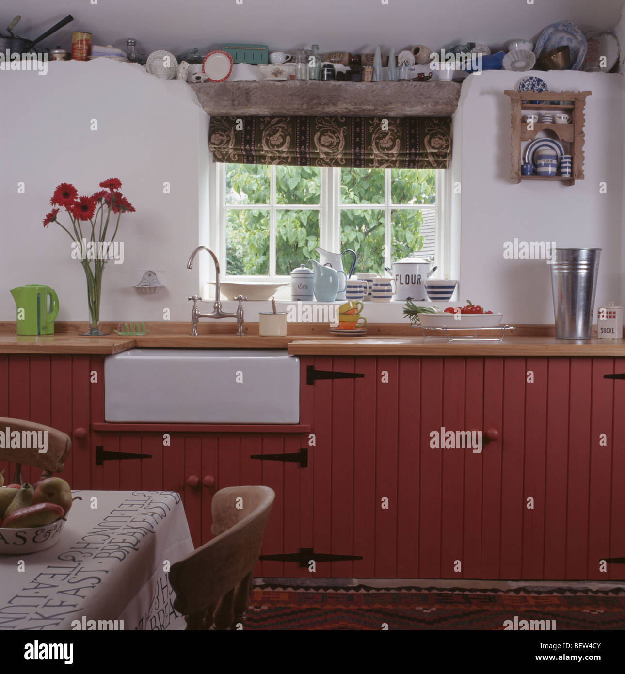 White Belfast sink below window in white cottage kitchen with pink ...