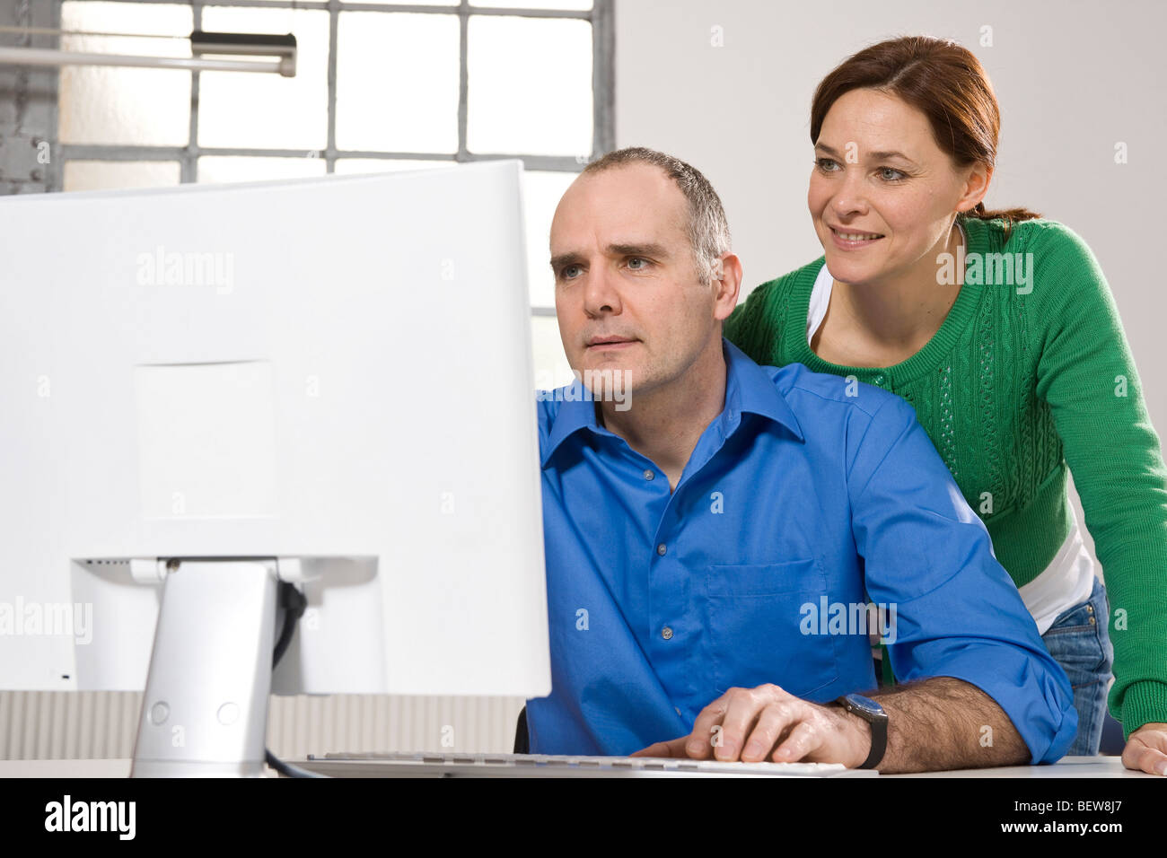 Couple looking at computer screen Stock Photo - Alamy