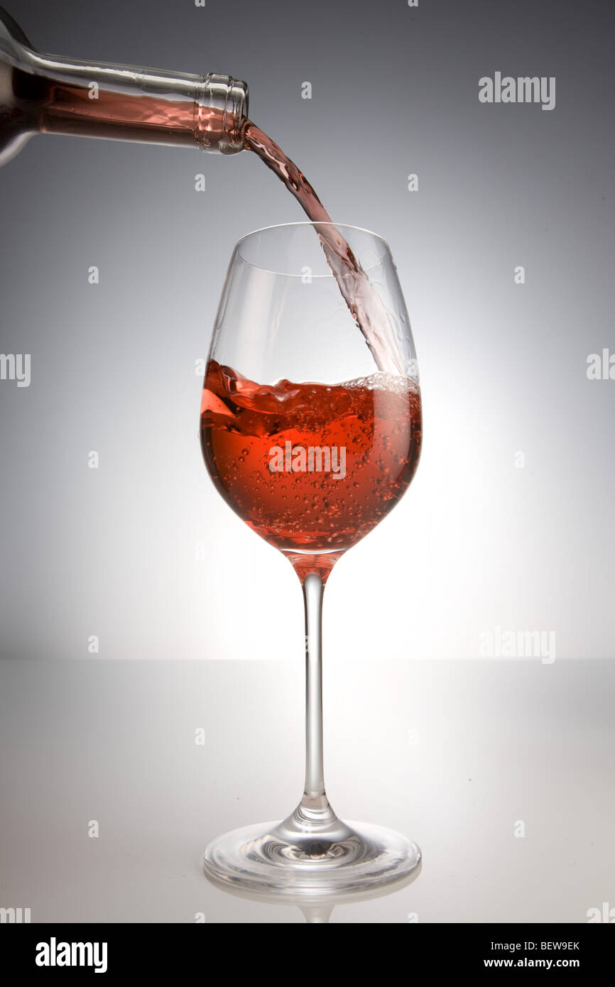 pouring red wine into a glass, close-up Stock Photo - Alamy