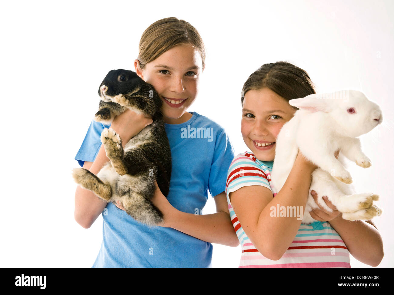 two girls holding rabbits, Studio Shot Stock Photo - Alamy