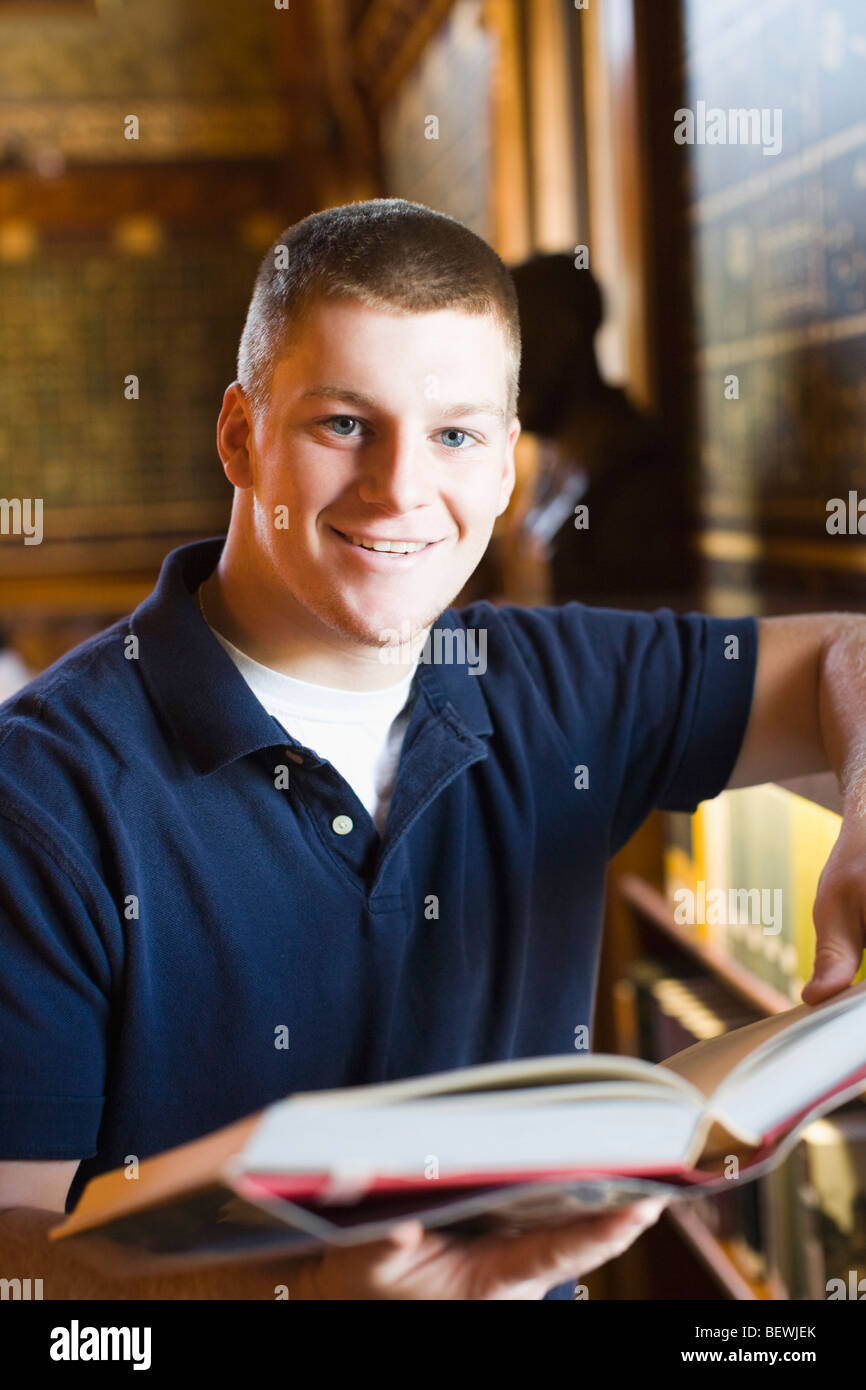 Student reading a book in a library Stock Photo - Alamy