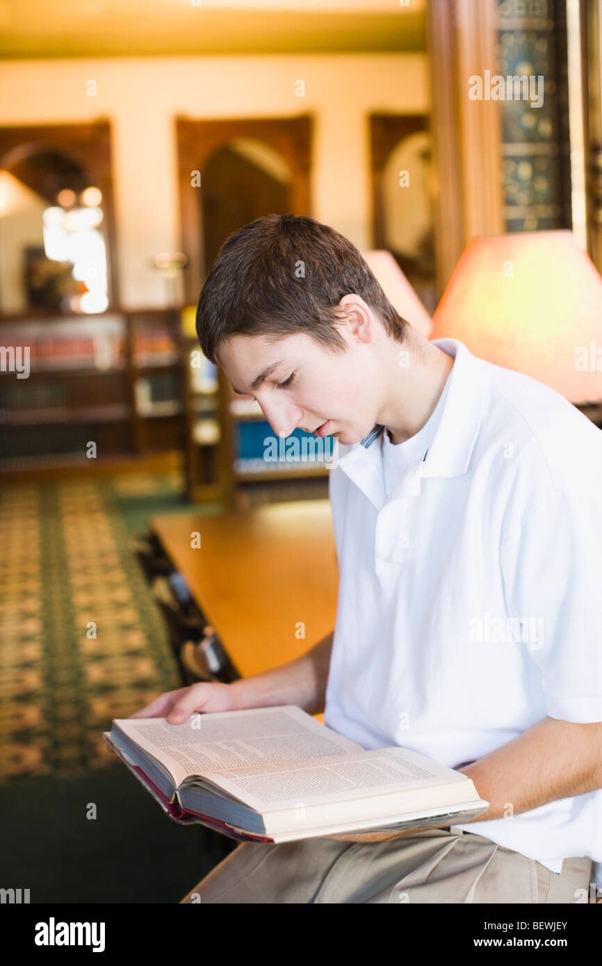 Student reading a book in a library Stock Photo - Alamy
