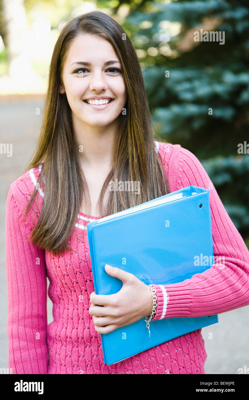 Student holding a file and smiling Stock Photo - Alamy