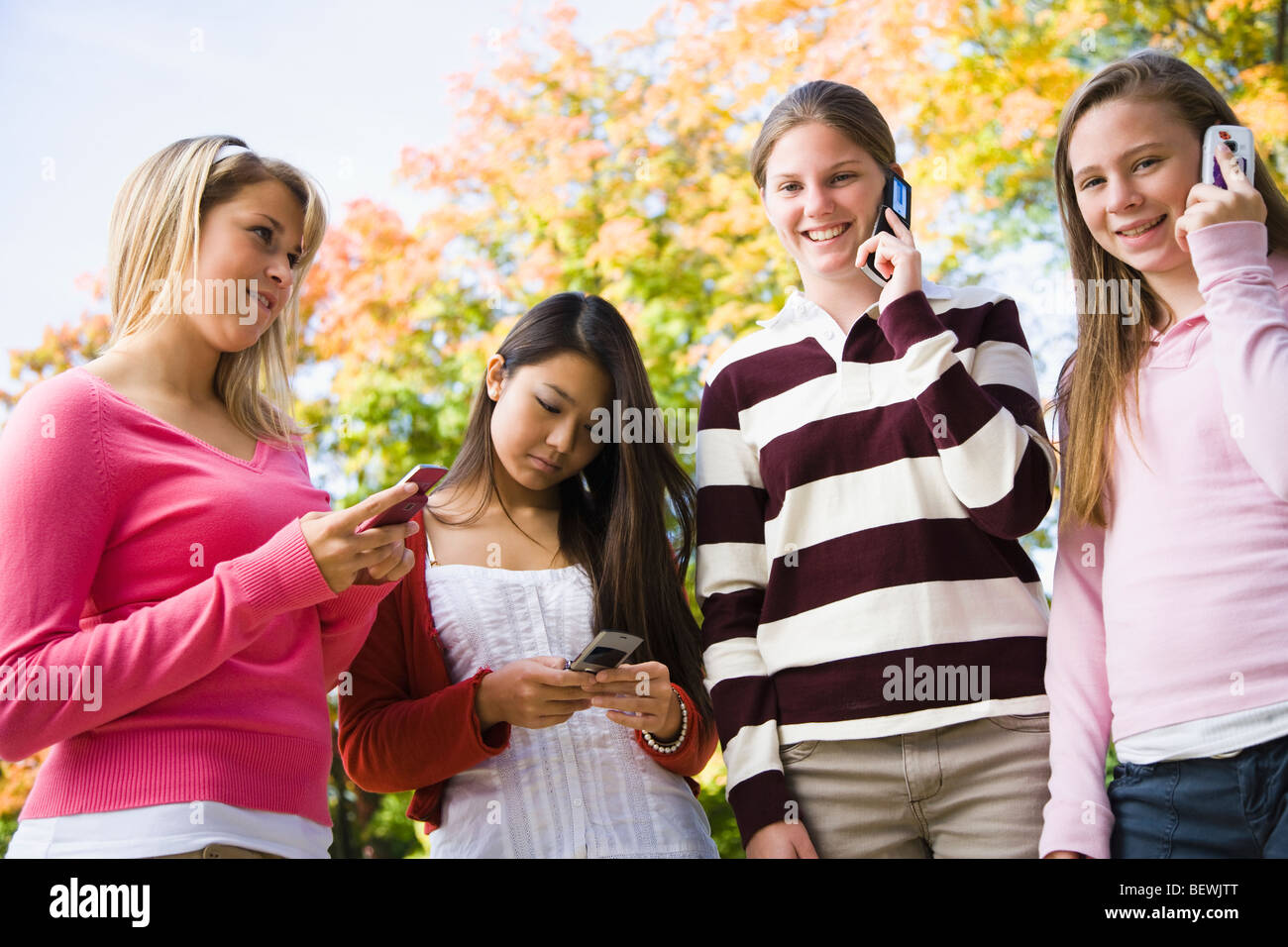 Four students using mobile phones Stock Photo - Alamy