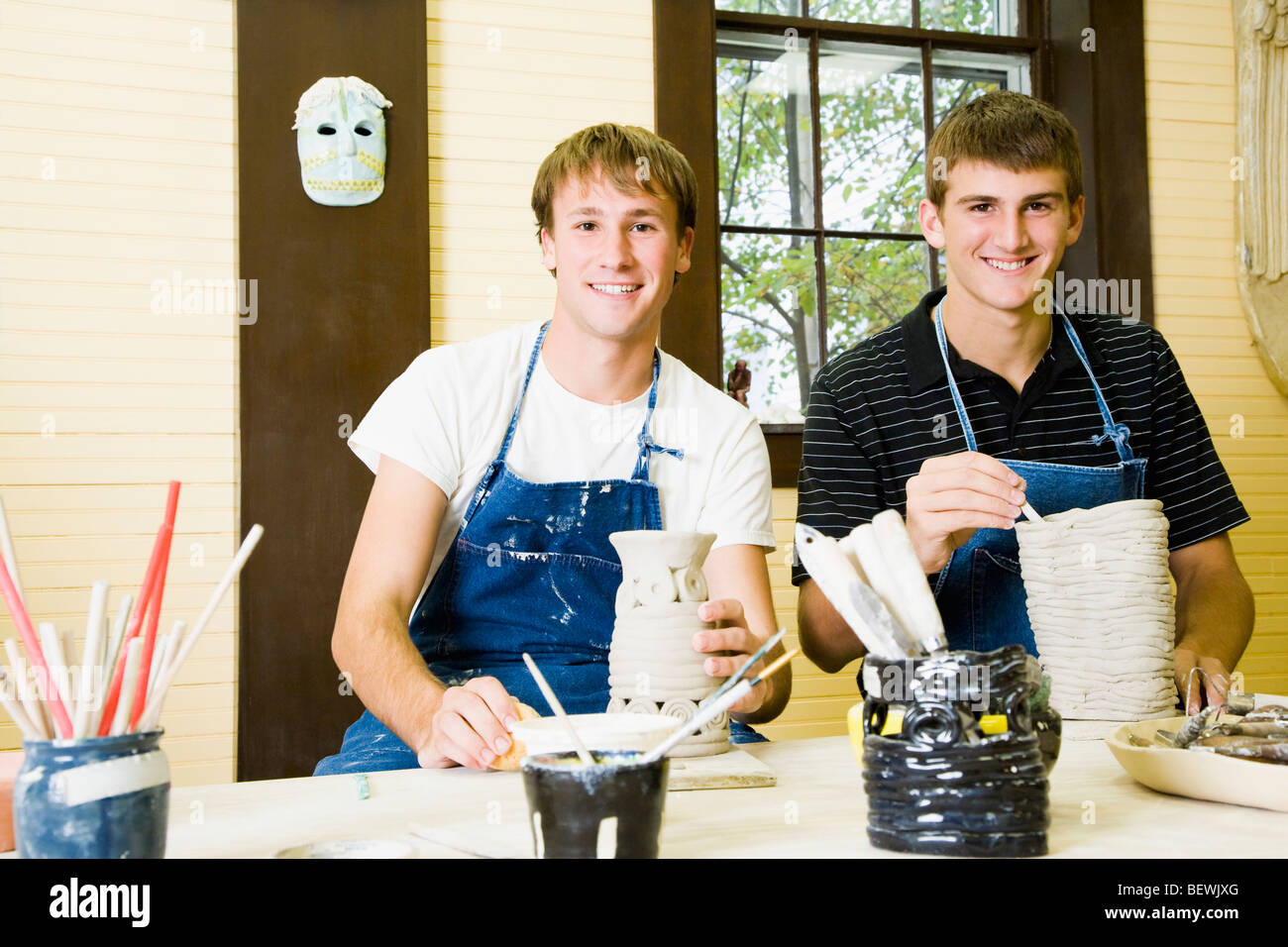 Portrait of two students coloring clay pots in a pottery class Stock ...