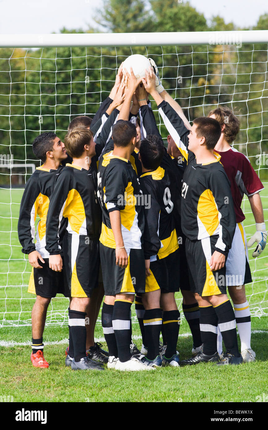 Soccer team in a huddle in a soccer field Stock Photo - Alamy